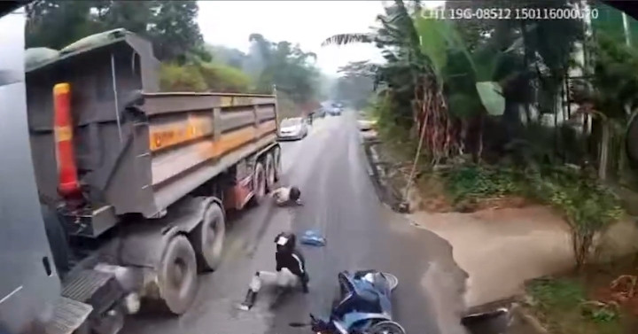 Vượt ẩu tại khúc cua, 2 người đi xe máy ngã ngay sát bánh xe ben