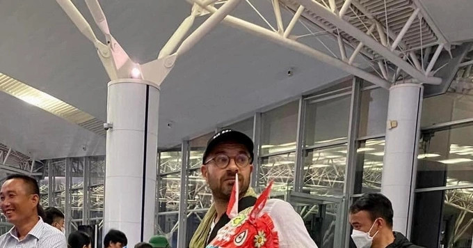 Foreign tourist shows off precious gift from Hanoi: votive paper horse